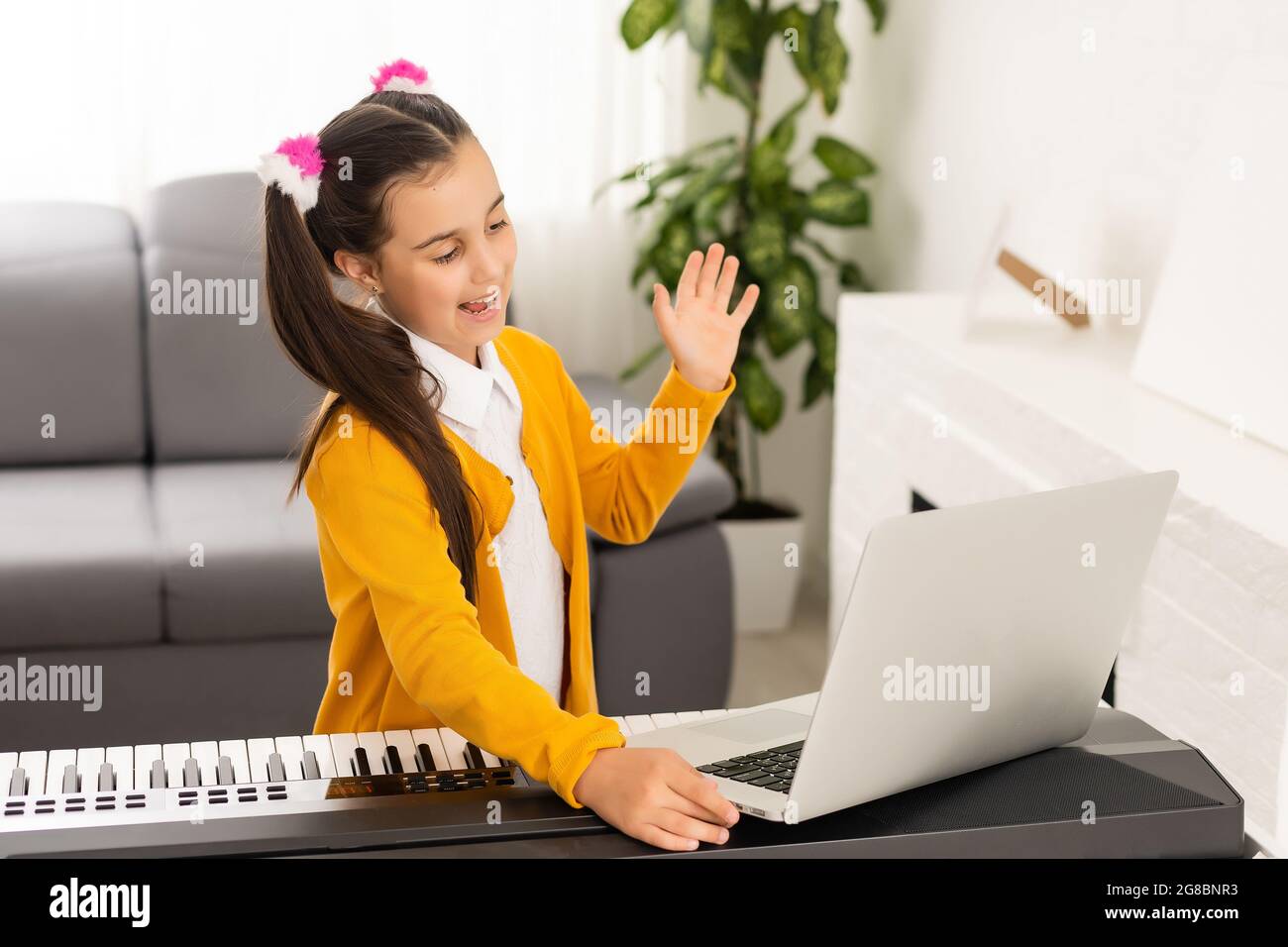 Little girl watching online lesson tutorial how to learn a synthesizer ...