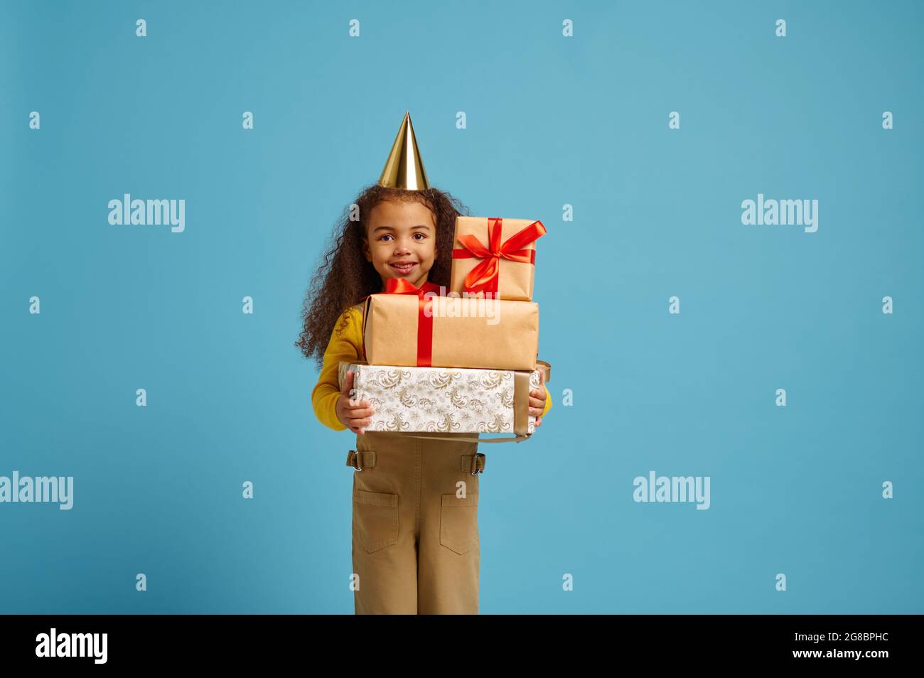 Funny little girl in cap holds birthday gift box Stock Photo - Alamy