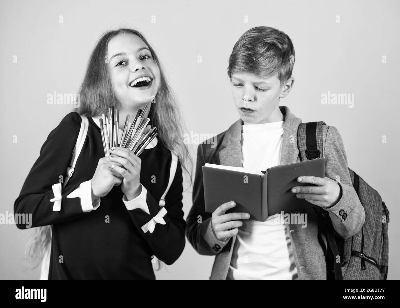 We are writing our future. Happy boy and girl hold pens and copybook ...