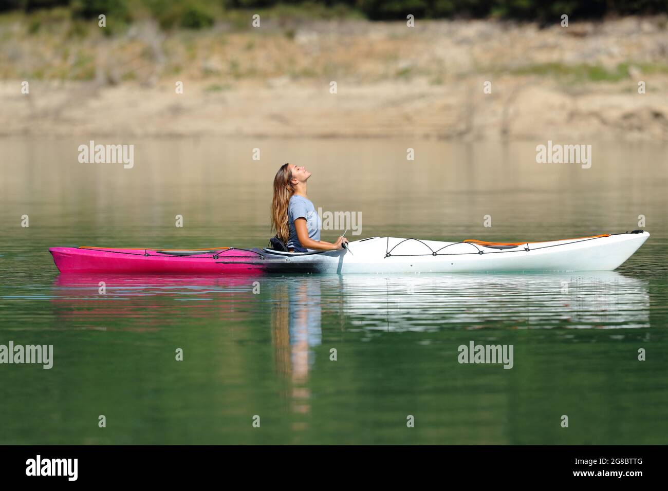 Side view portrait of a woman relaxing in a kayak breathing fresh air ...