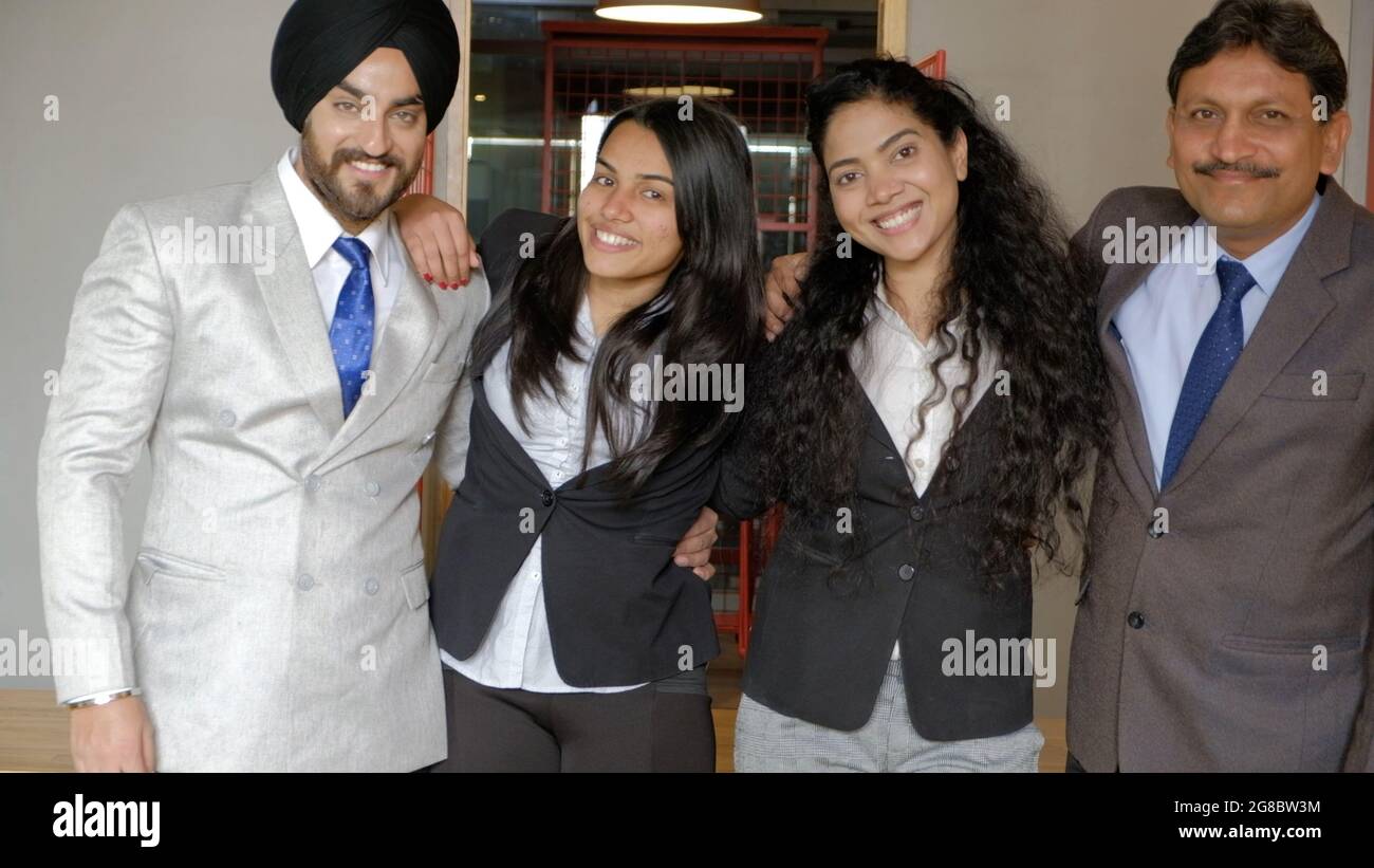 Closeupshot of a group of Indian colleagues smiling for the camera ...