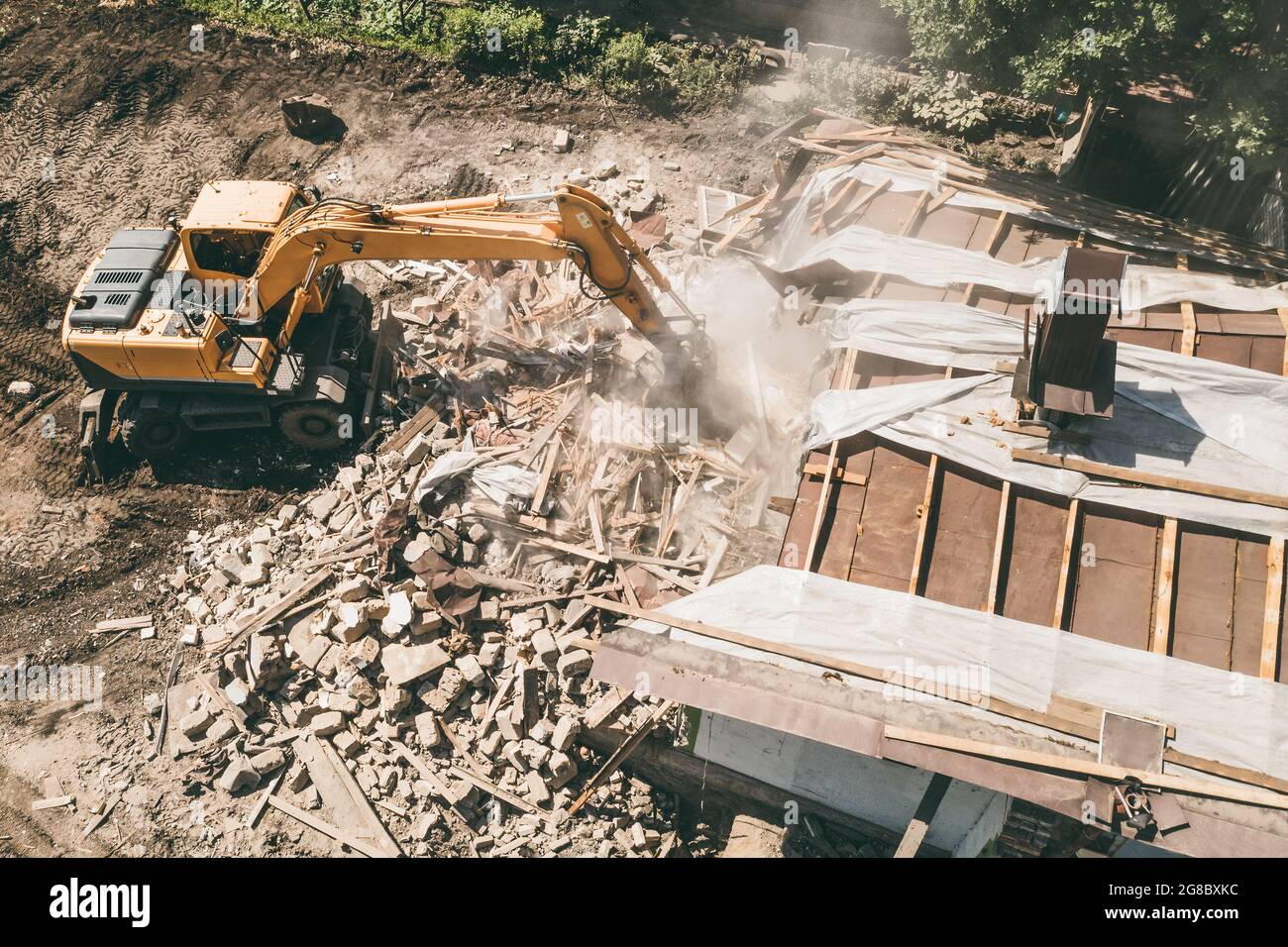 Demolition of building by industrial excavator. Bucket breaks walls and ...