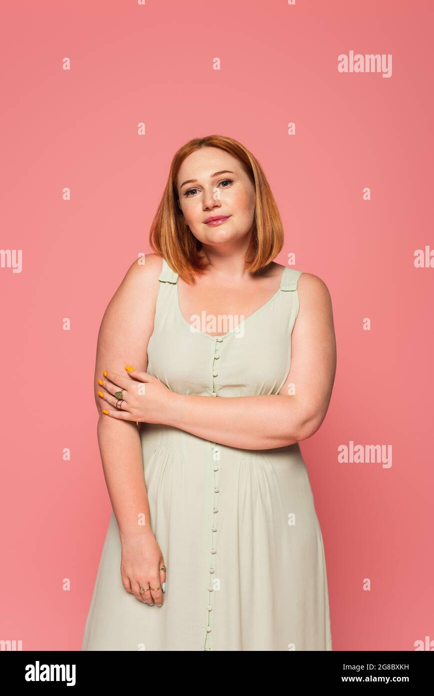 Pretty plus size woman looking at camera isolated on pink Stock Photo ...