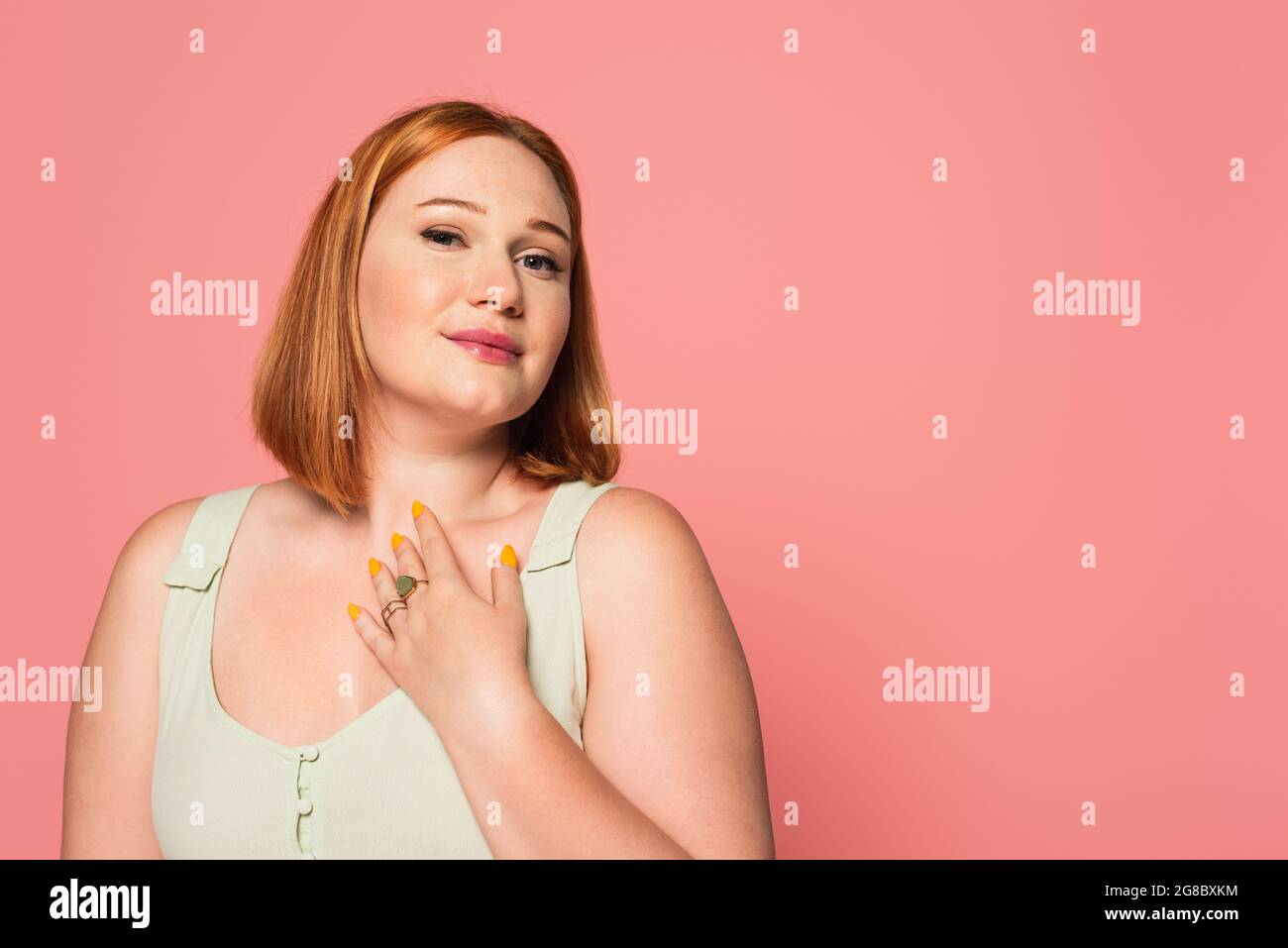 Plus size woman looking at camera isolated on pink Stock Photo - Alamy