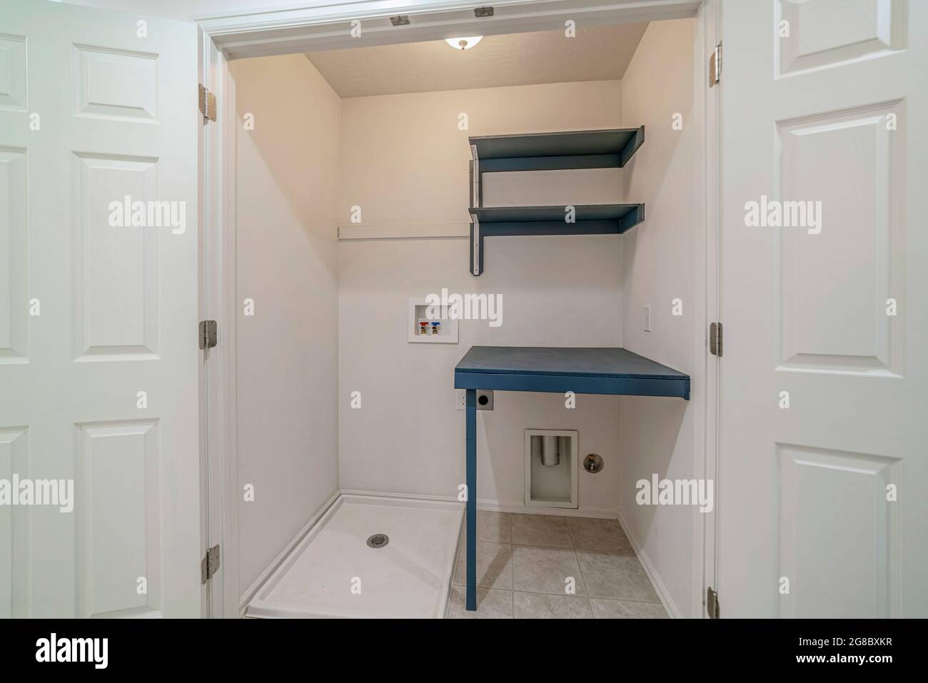 Empty laundry room with tables and laundry connections Stock Photo - Alamy