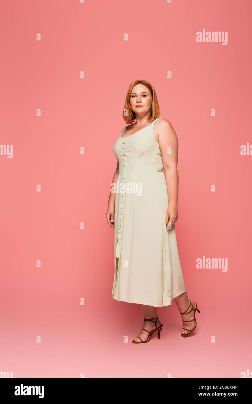 Stylish plus size woman walking on pink background Stock Photo - Alamy