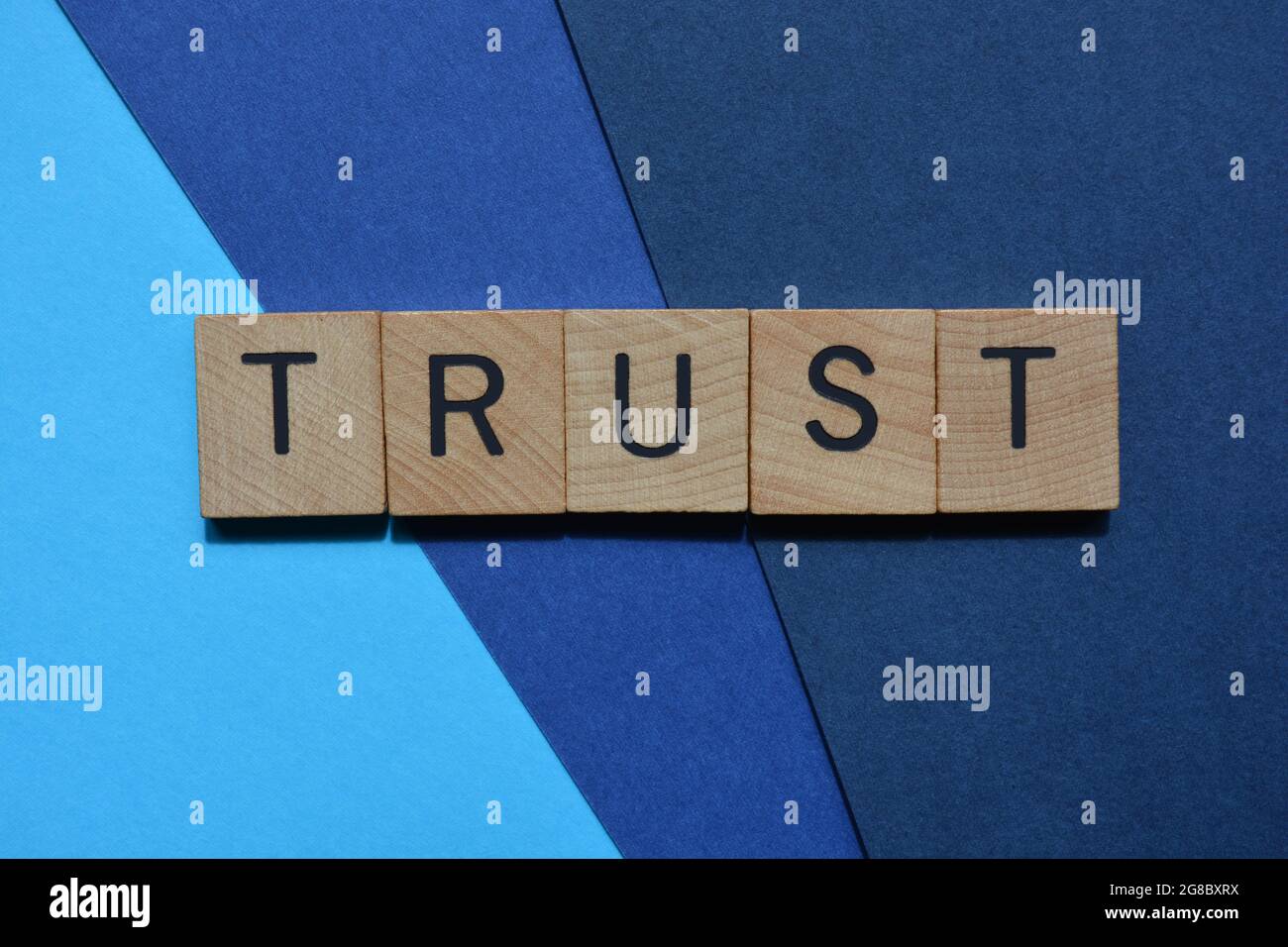 Trust, word in wooden alphabet letters on blue background Stock Photo ...