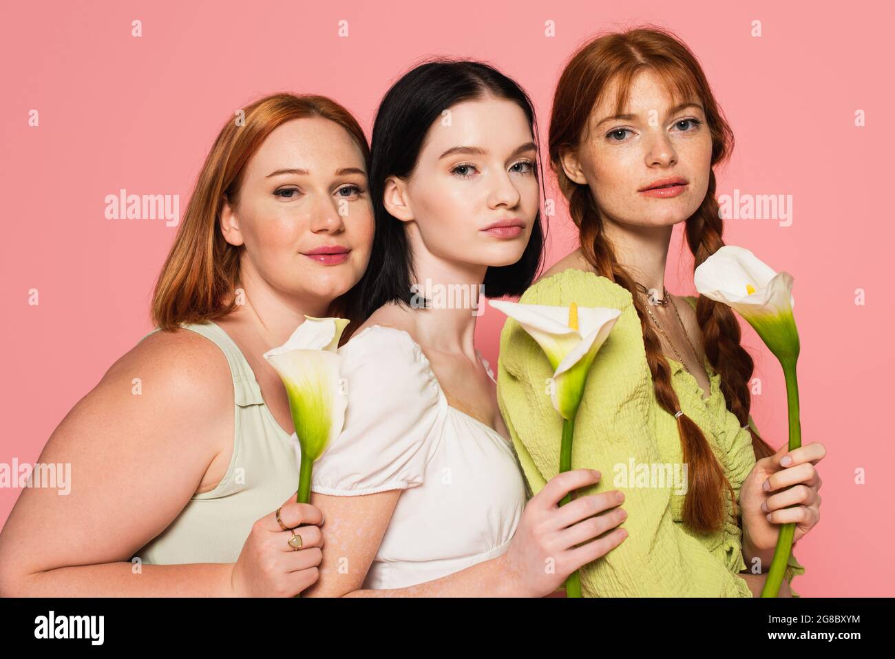 Pretty body positive women holding flowers isolated on pink Stock Photo ...