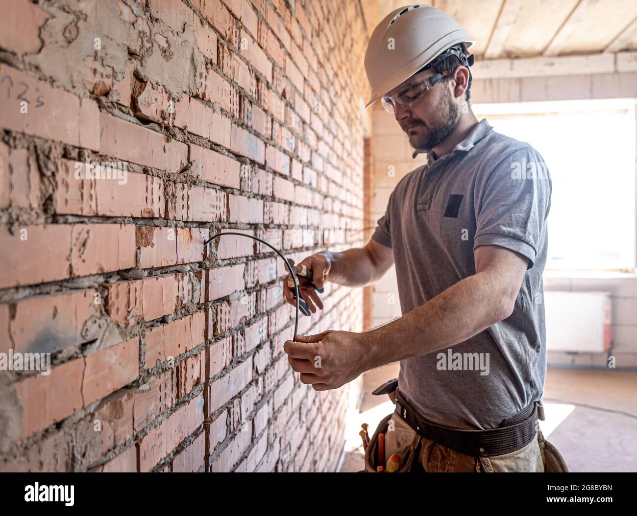 A construction electrician cuts a voltage cable during a repair Stock ...