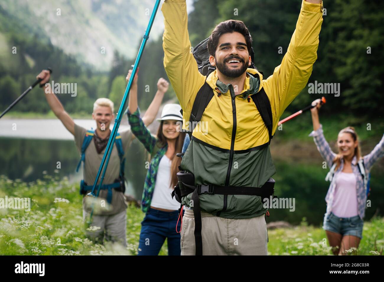 Group of friends hiking together outdoors exploring the wilderness and ...