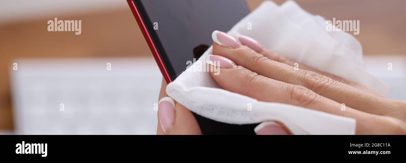 Woman wiping screen of mobile phone with damp cloth closeup Stock Photo ...