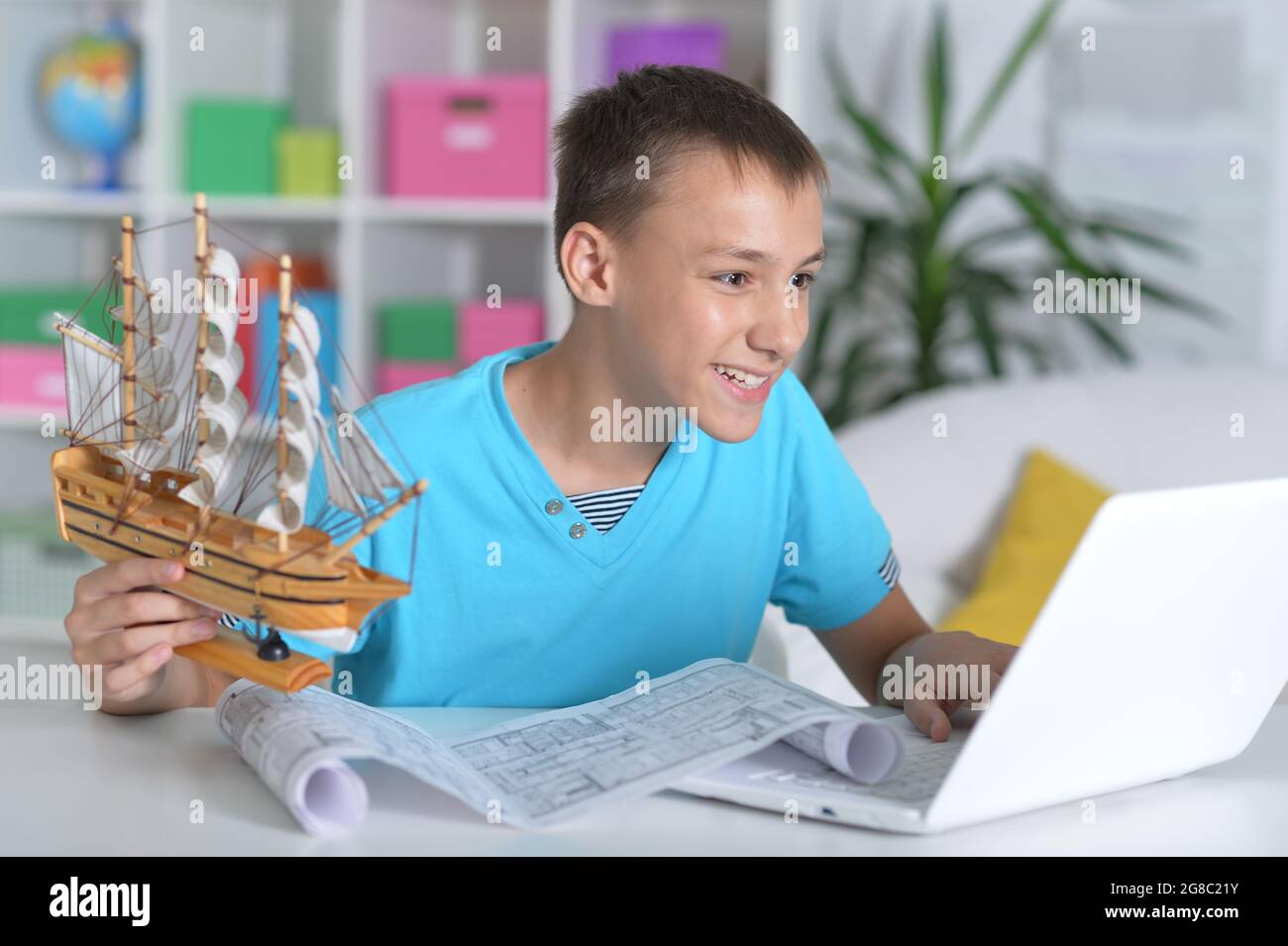 Portrait of a boy with a homemade toy-ship Stock Photo - Alamy