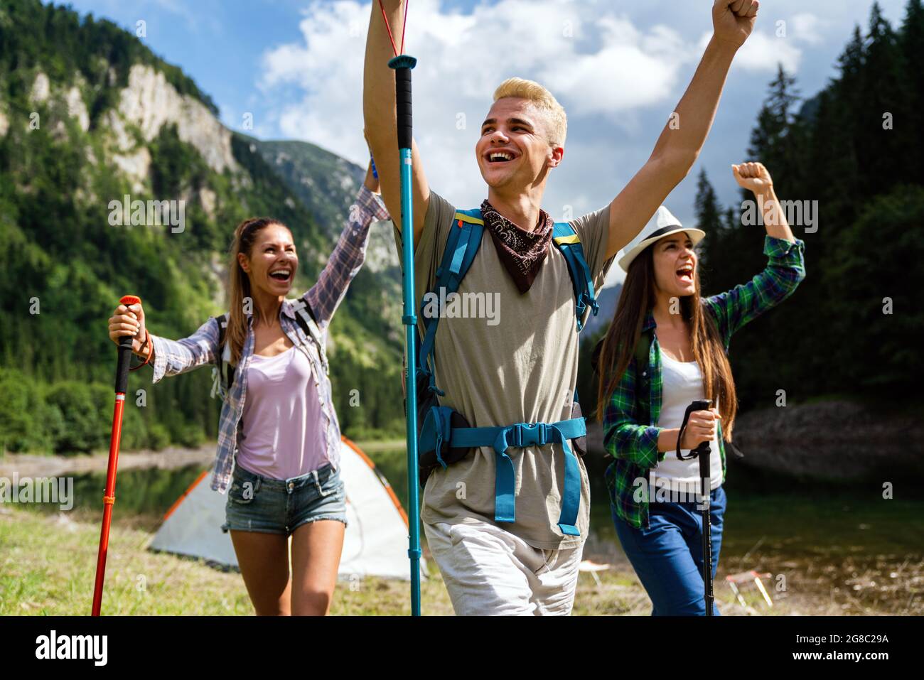 Group of friends hiking together outdoors exploring the wilderness and ...