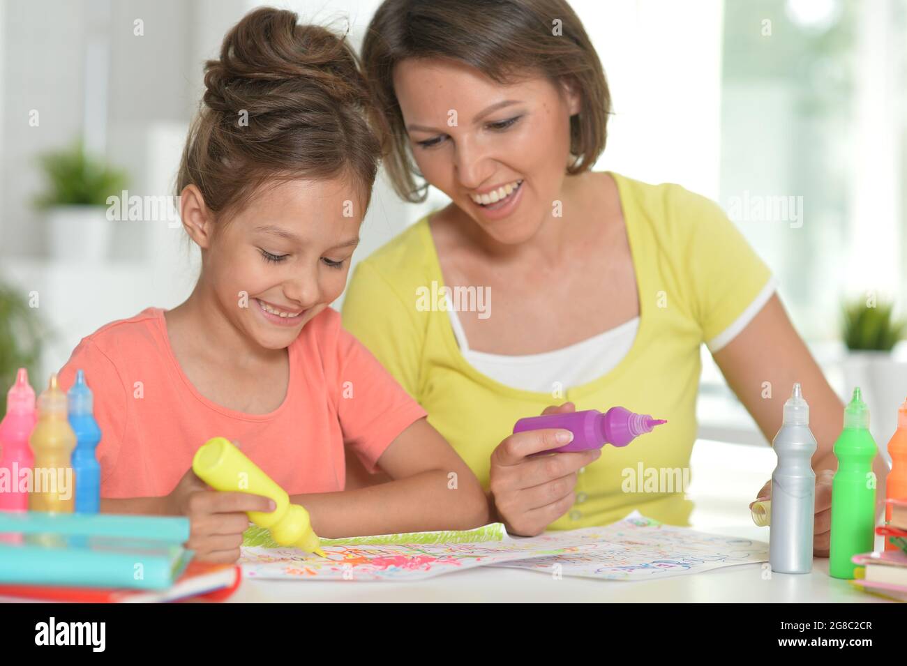 Cute girl with mother drawing at home Stock Photo - Alamy