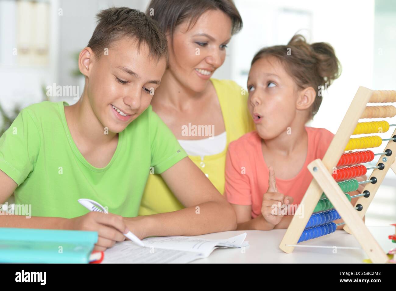 Portrait of mother helping children with homework Stock Photo - Alamy