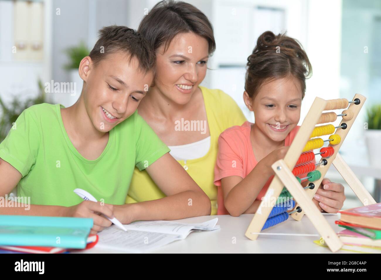 Portrait of mother helping children with homework Stock Photo - Alamy