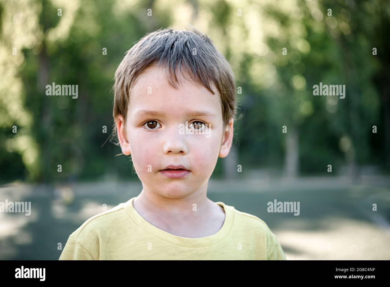 A cute little boy in yellow T-shirt in the football field Stock Photo ...