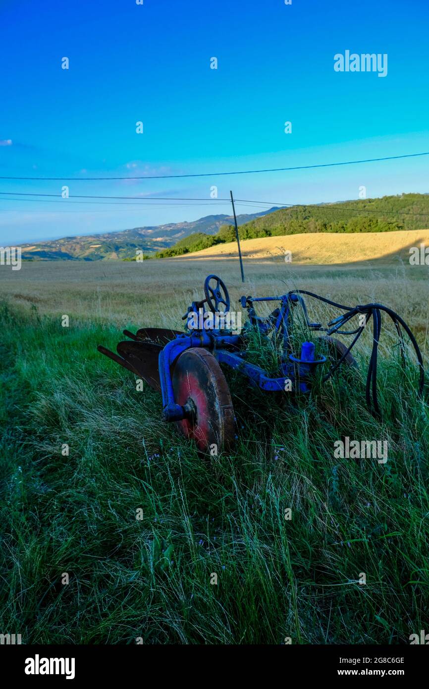old blue tractor on the field. Sunset over the agricultural field ...
