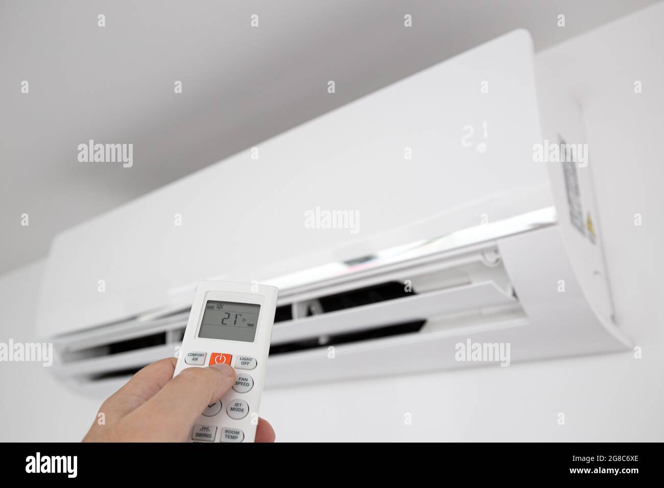 Hand operating a Remote control of a Domestic Air conditioner unit ...