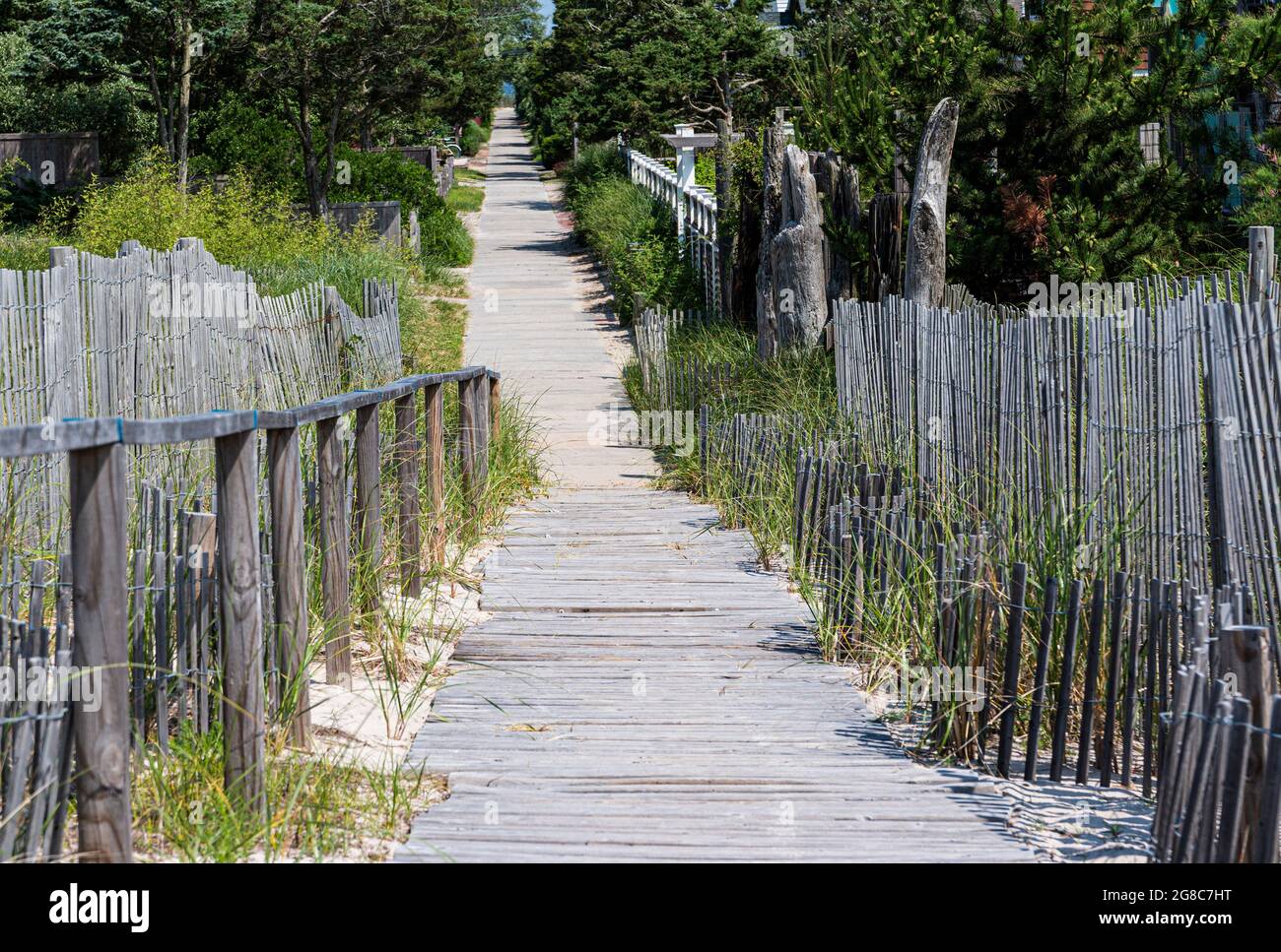 Walking over the sand dunes on a wooden path exiting the beach into the ...