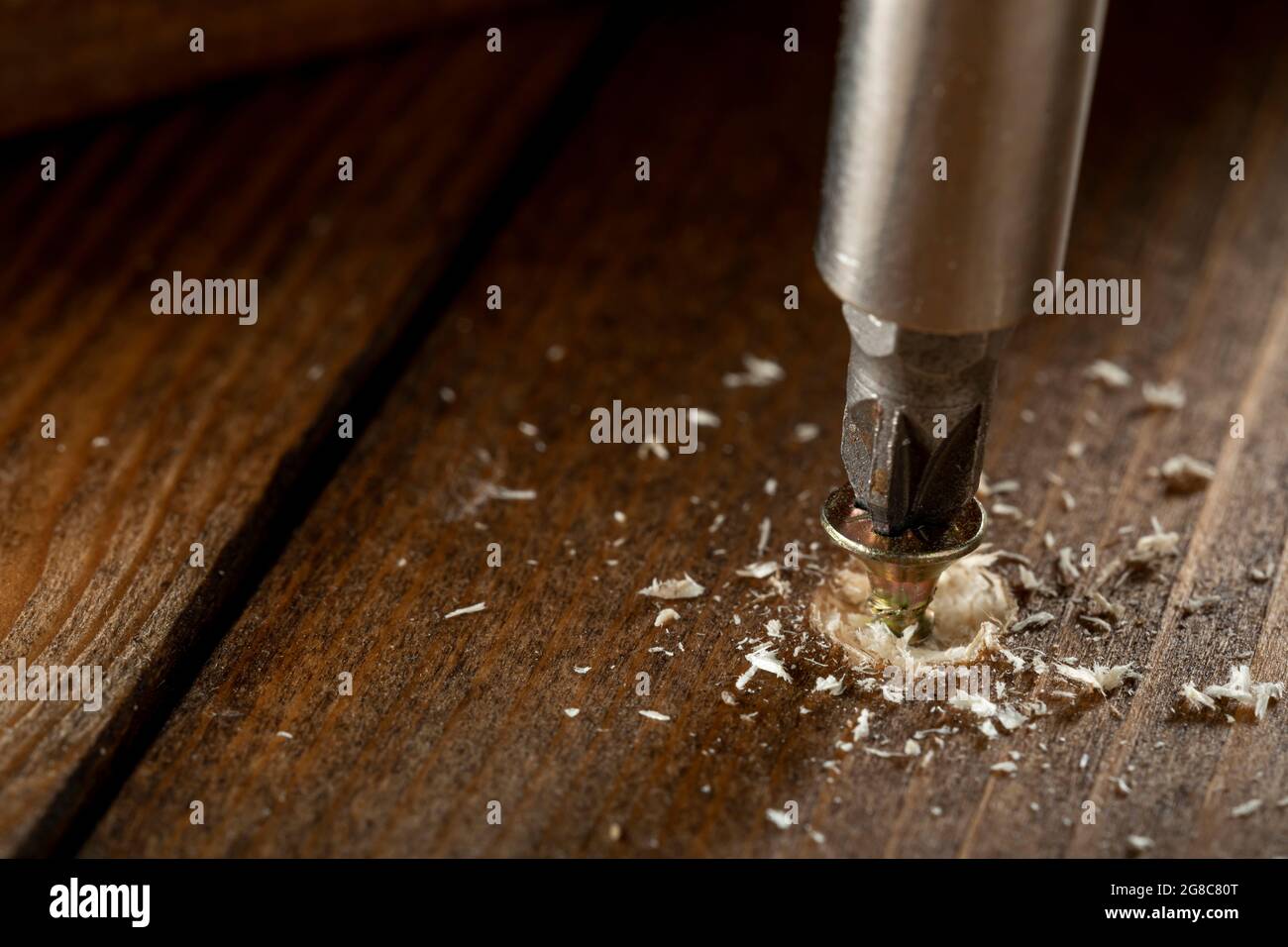 Self-tapping screw screwed into a wooden board close-up. Screw for wood ...