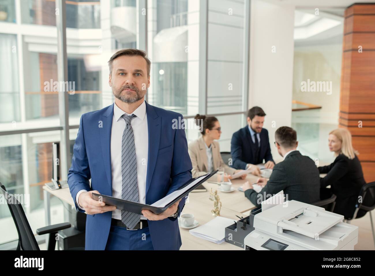 Sitting leadership looking at camera confidence document hi-res stock ...