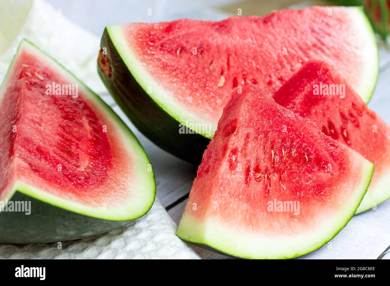 Bright sweet red and green watermelon slices in summer on light table ...