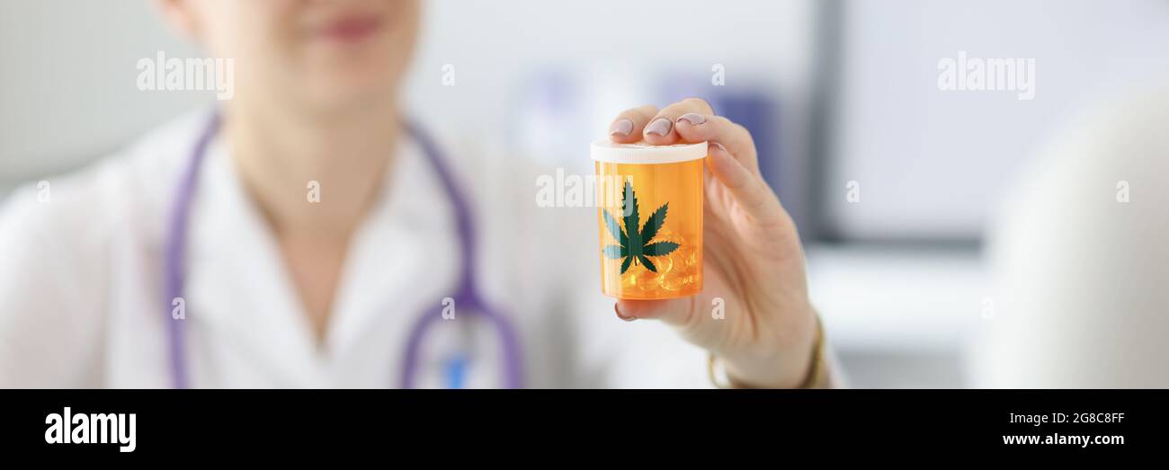 Doctor holding jar of marijuana pills closeup Stock Photo - Alamy