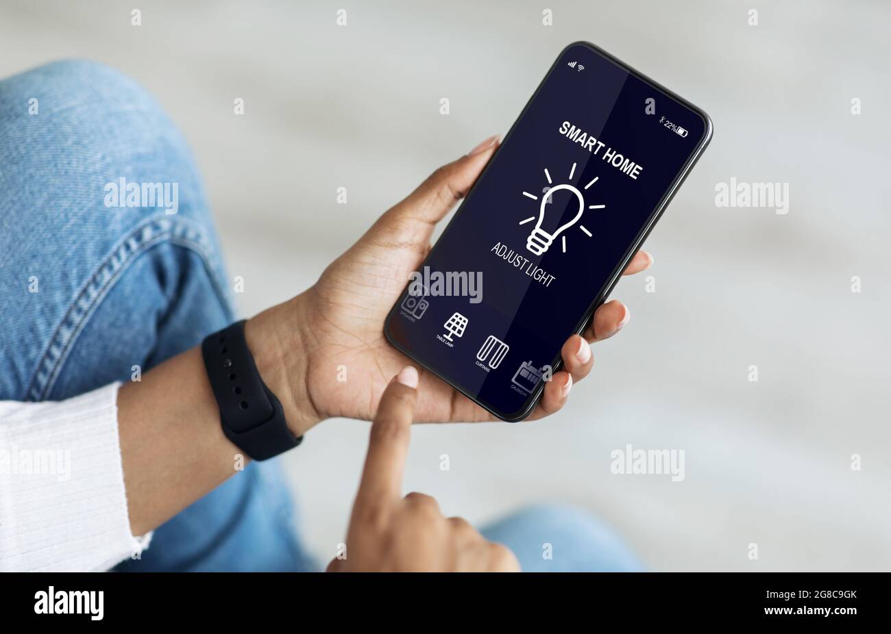 Smart home control by phone. Gadget in female hand. Managing lighting ...