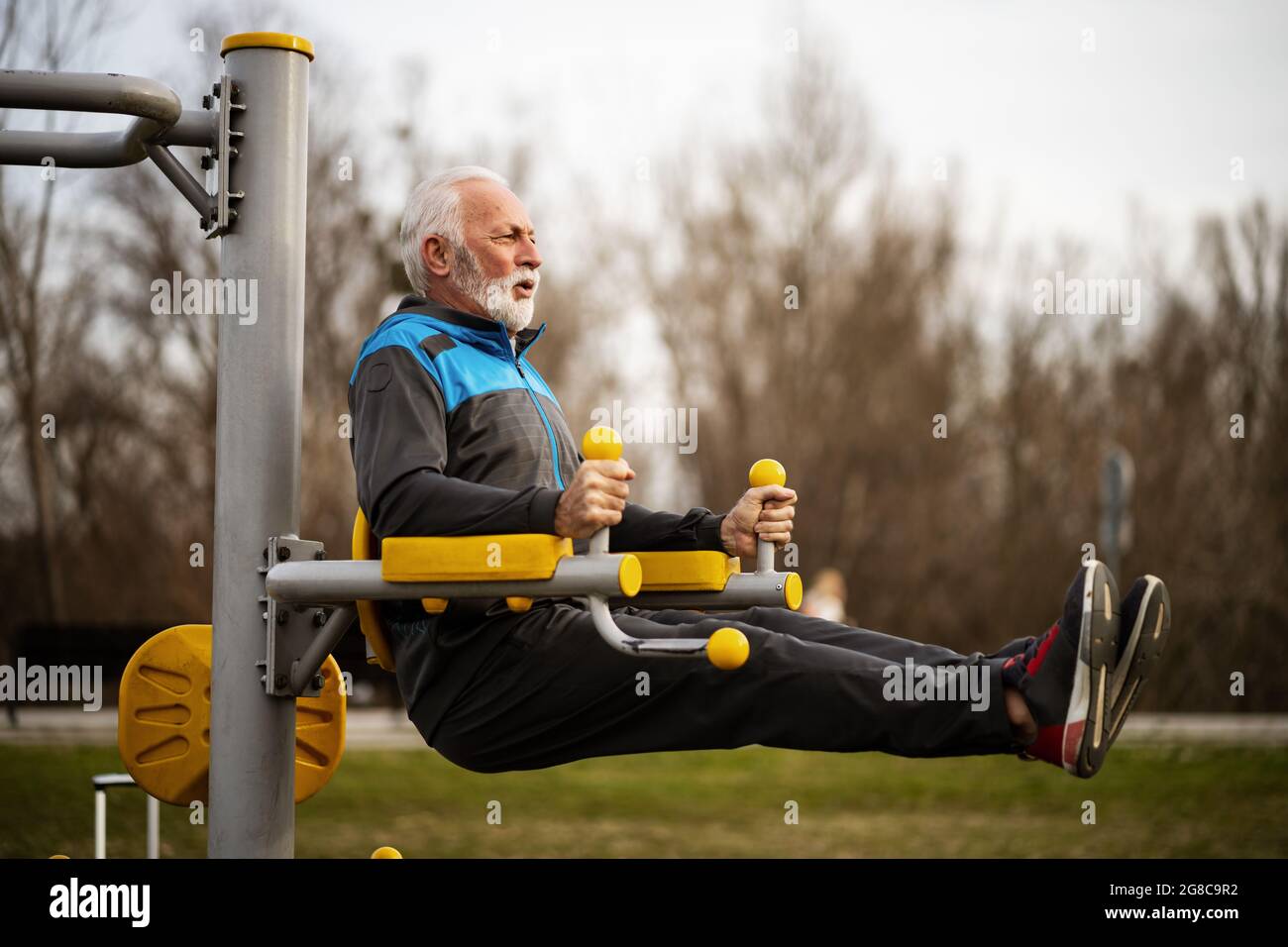 Active senior man is exercising on outdoor gym. Healthy retirement ...