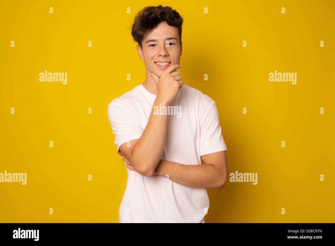 Young handsome man wearing casual t-shirt standing over isolated yellow ...