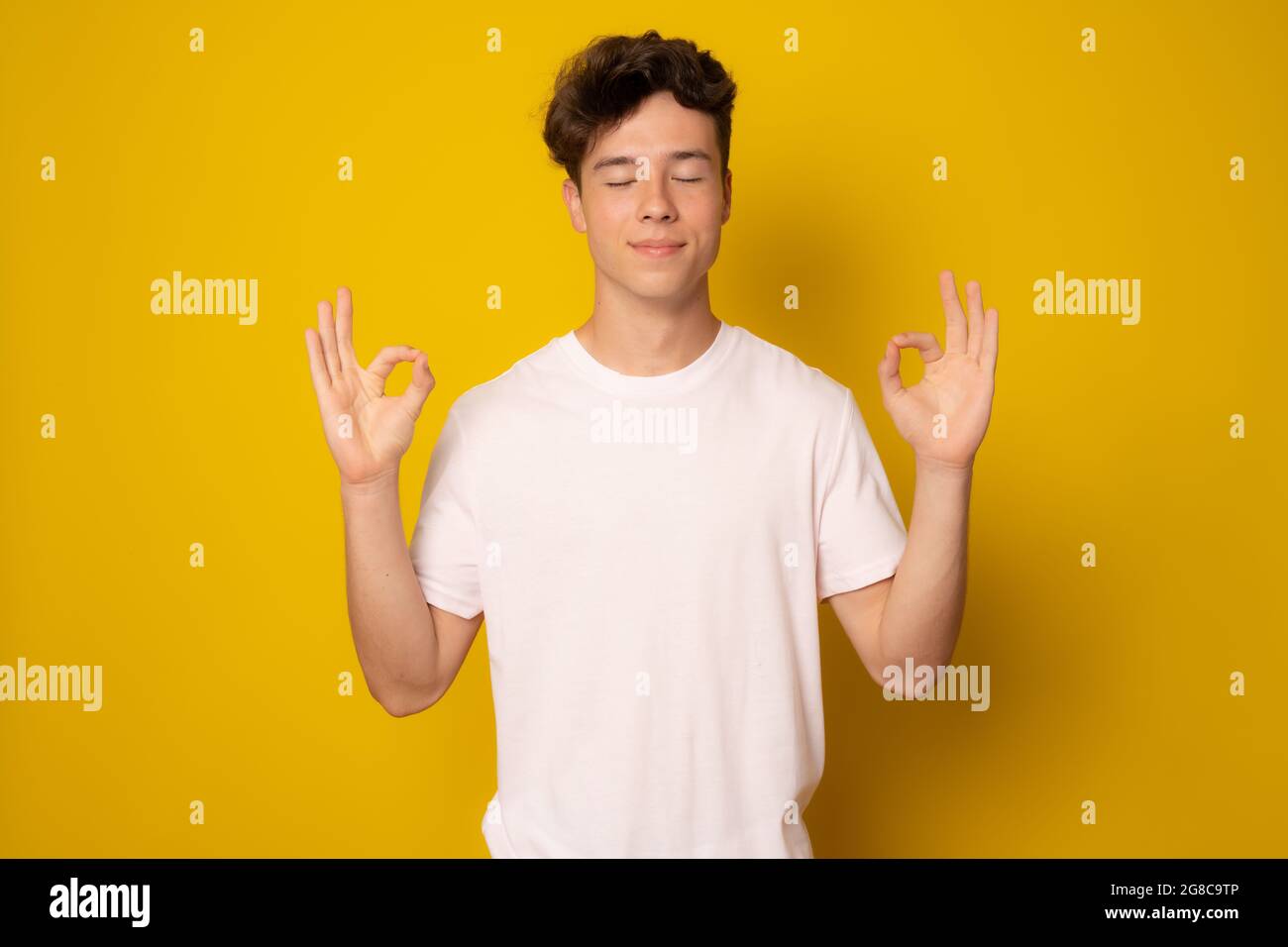 Young handsome man wearing casual t-shirt standing over isolated yellow ...