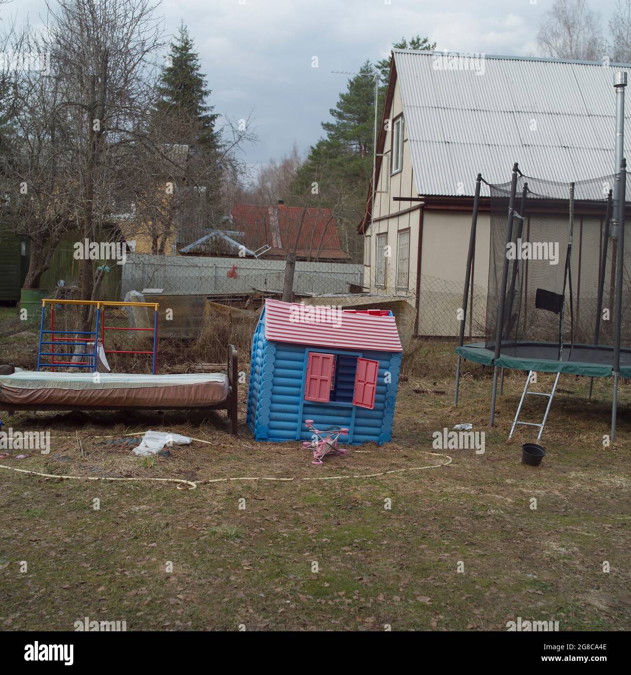Messy yard with a toy house and abandoned furniture, outdoor photo ...