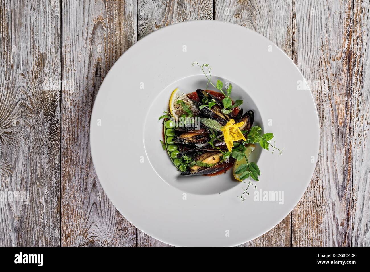 Appetizing mussels with vegetables and wine sauce on a white plate ...