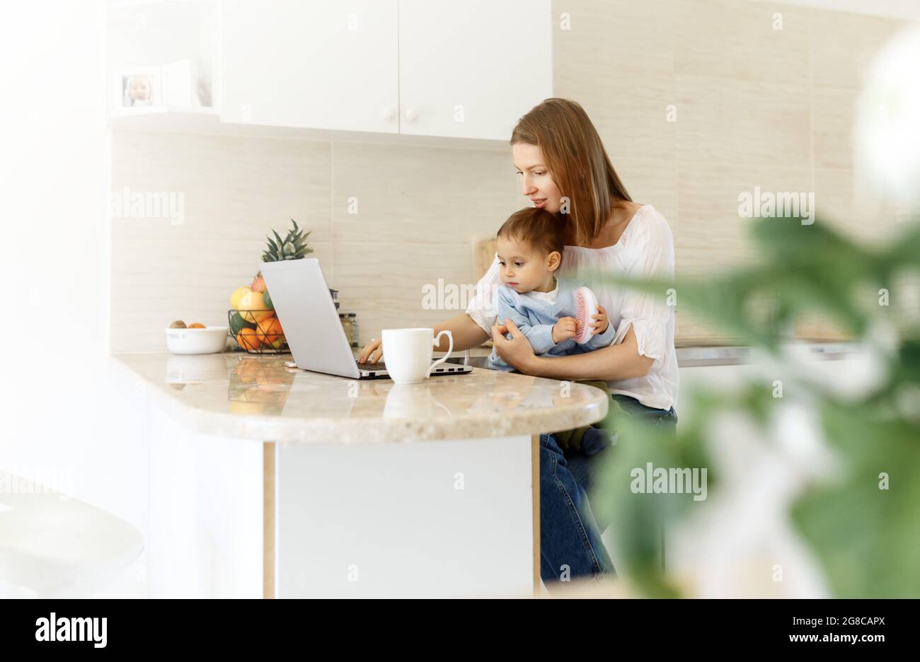 young woman with baby using laptop . Blogger, writer, journalist ...