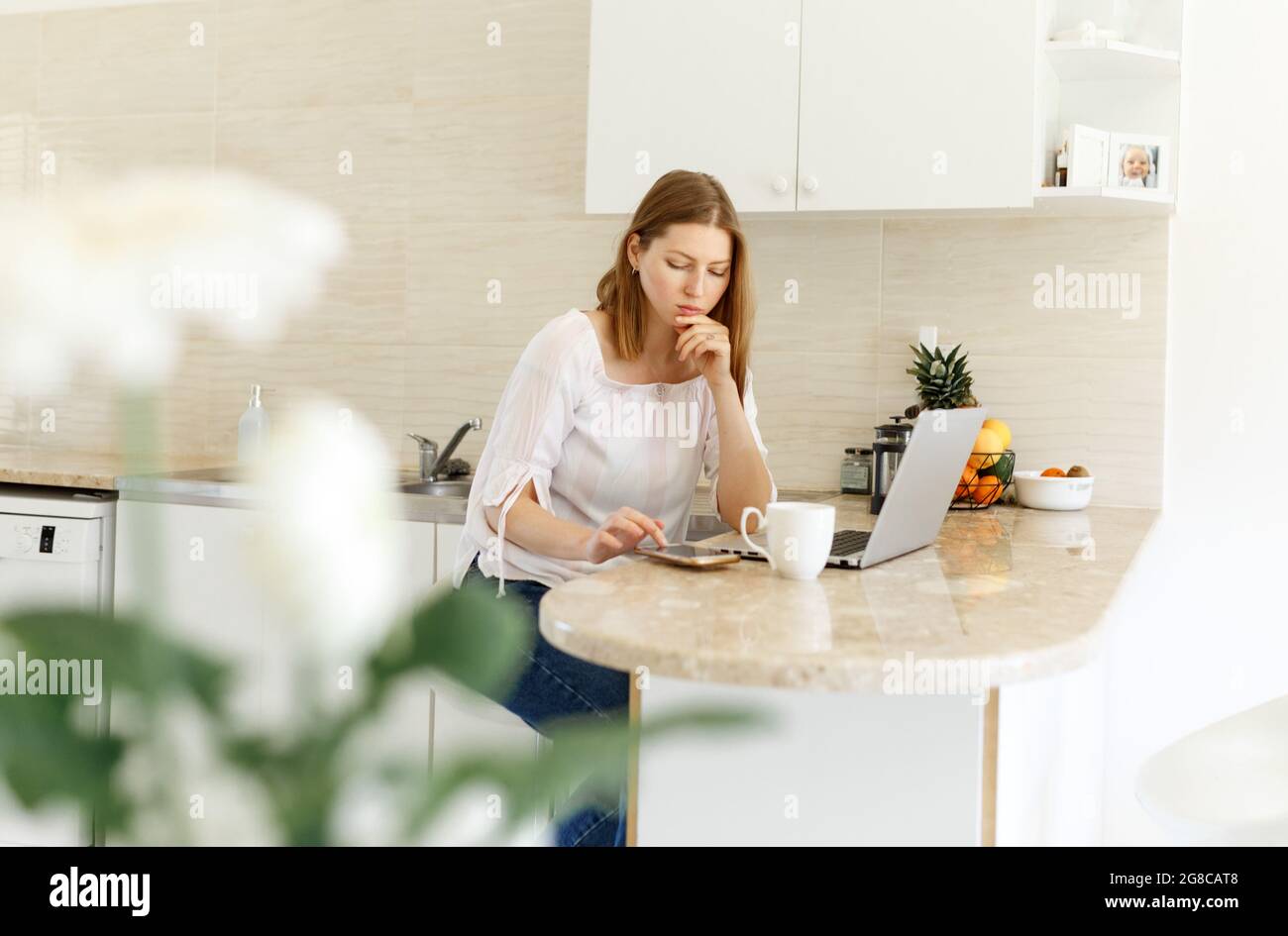 Cheerful young woman using laptop in office. Blogger, writer ...