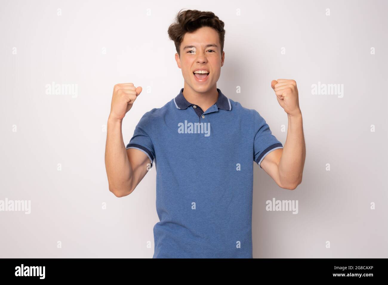 Happy winner. Happy young handsome man gesturing and keeping mouth open ...