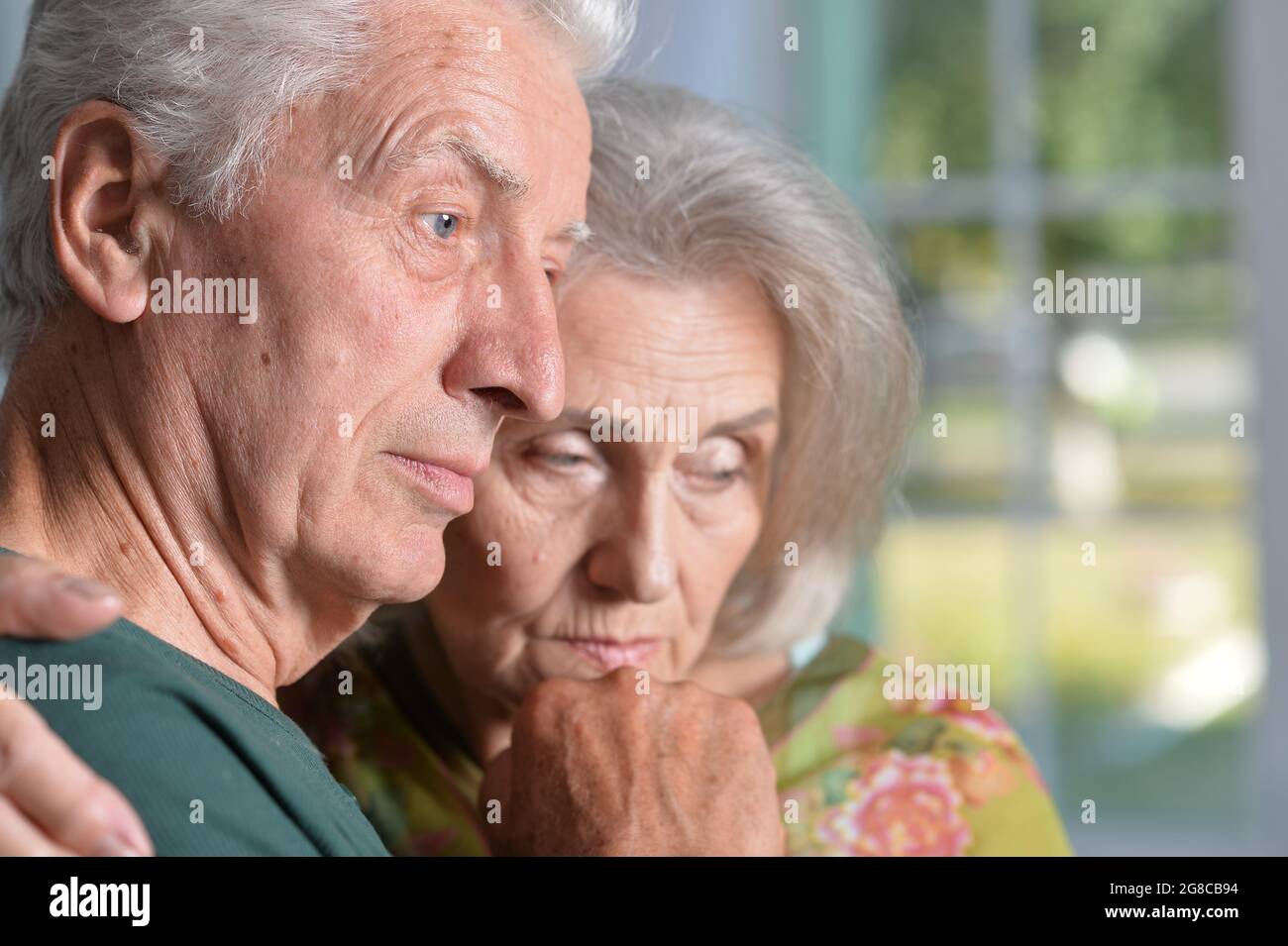 Portrait of sad senior couple posing at home Stock Photo - Alamy