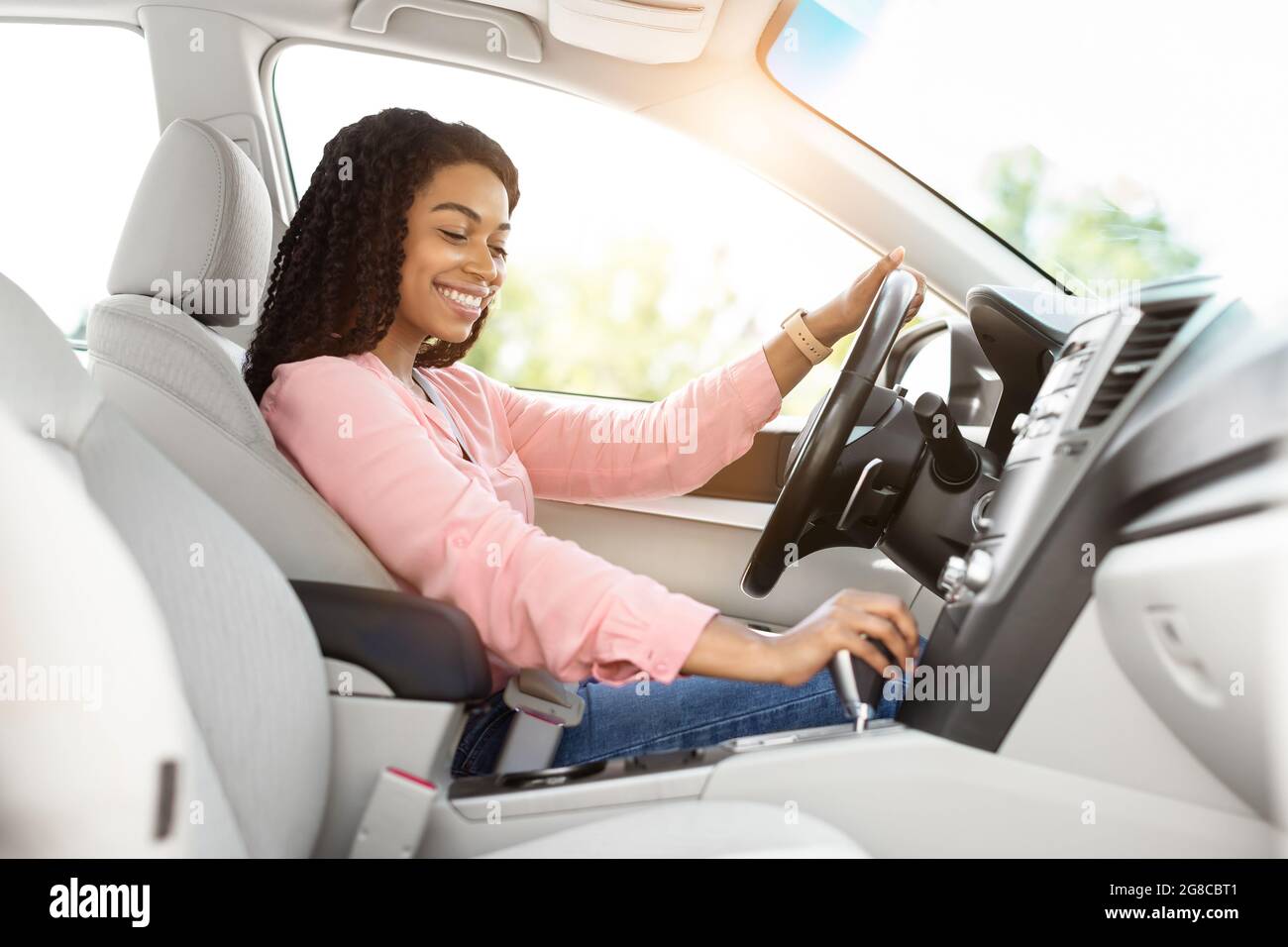Smiling black woman driving her new car in city Stock Photo - Alamy