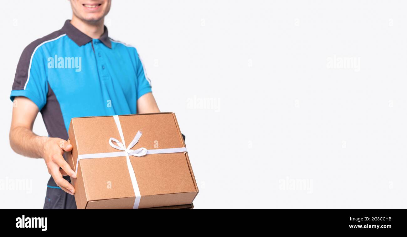 Delivery man holding cardboard box tied with the white tape and a bow ...