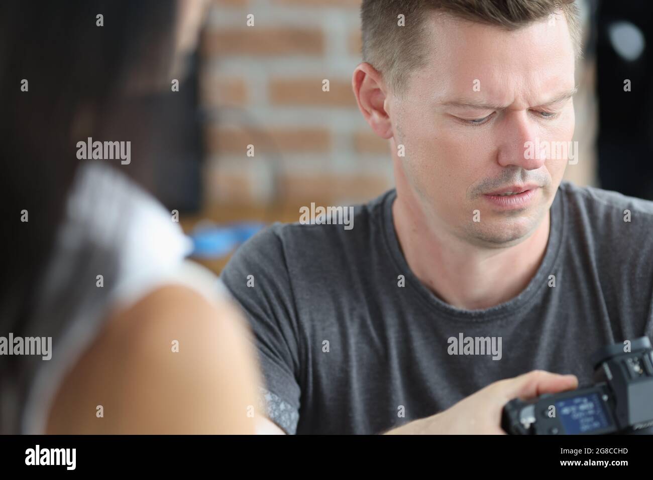 Male photographer is looking at camera screen with concentration Stock ...