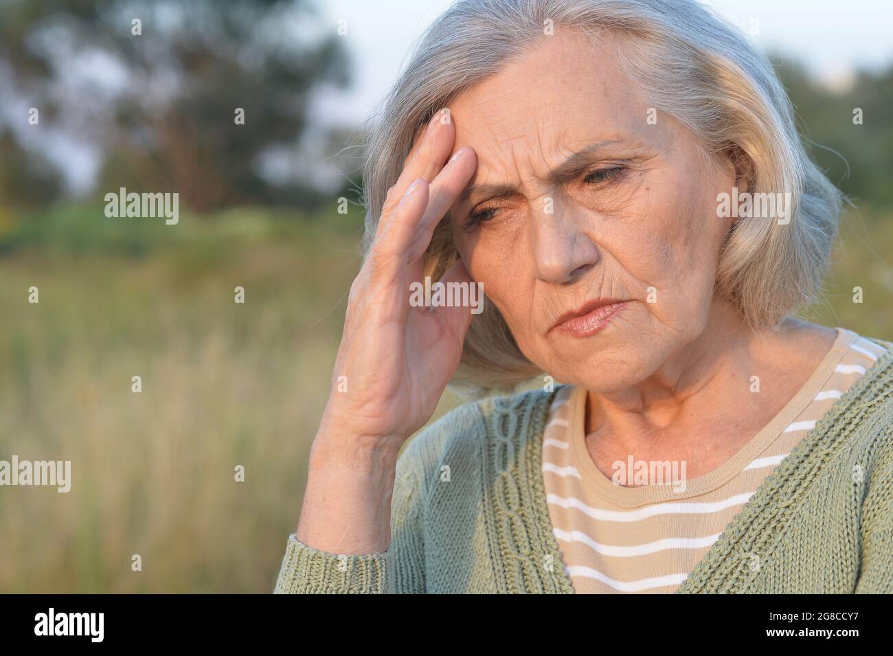 Portrait of sad senior beautiful woman in park Stock Photo - Alamy