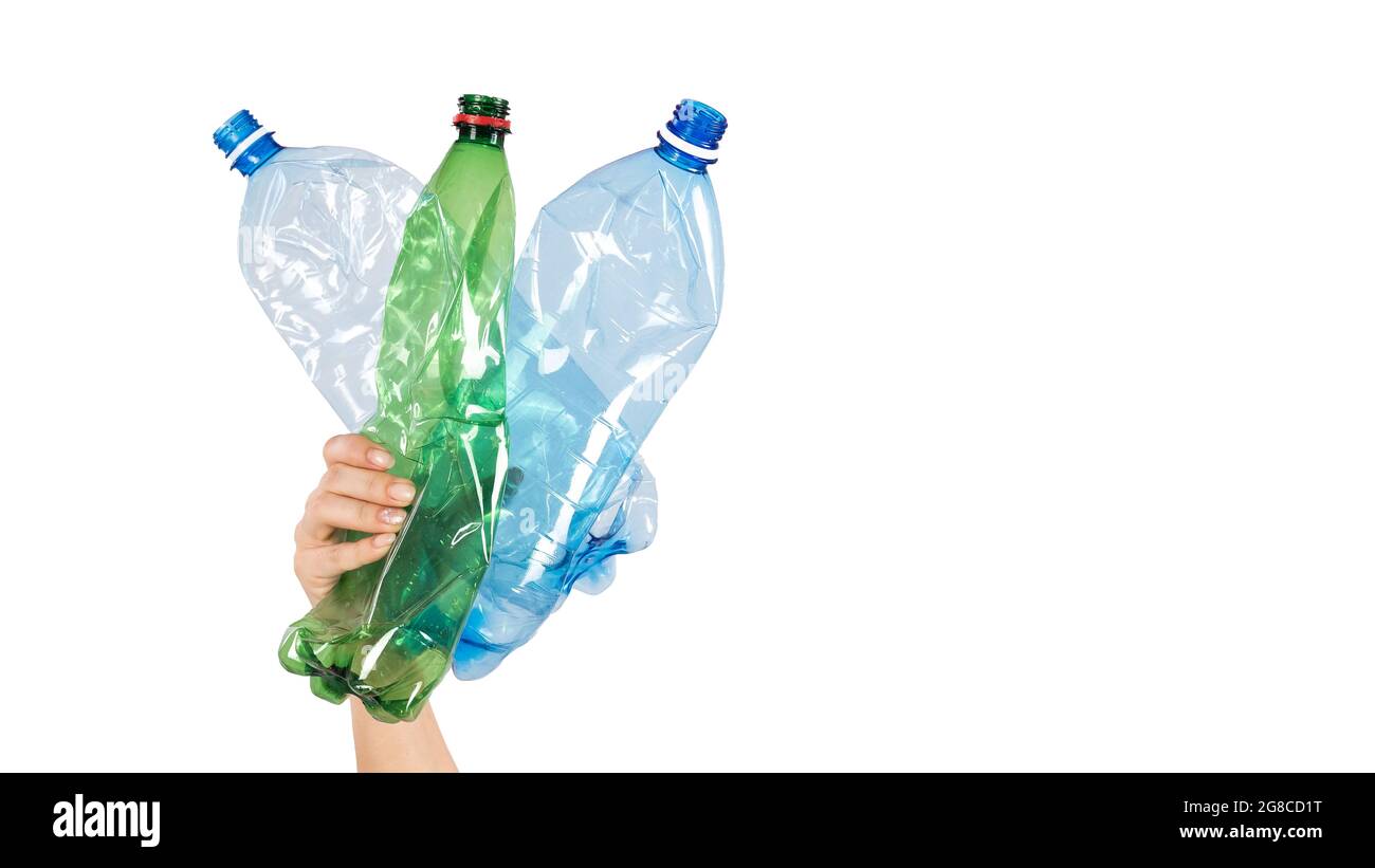 Close-up of a female hand holding plastic bottles on a white background ...