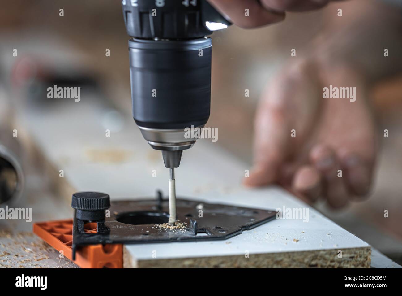 Screwing a self-tapping screw into a metal fastening hole on a wood ...