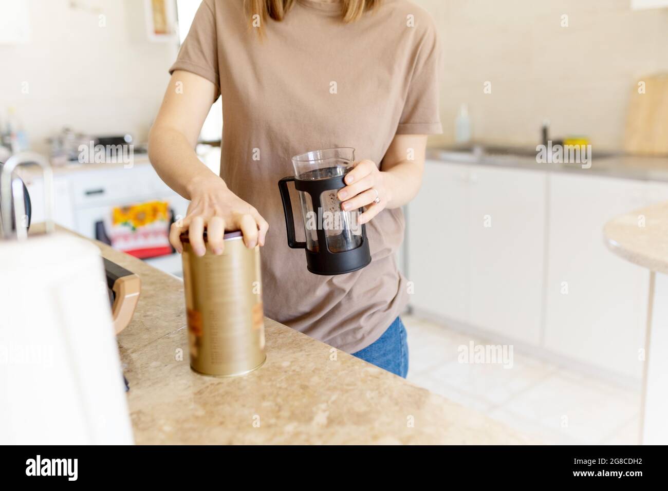 Woman pouring coffee in two coffee cups at morning. Girl put coffee in ...