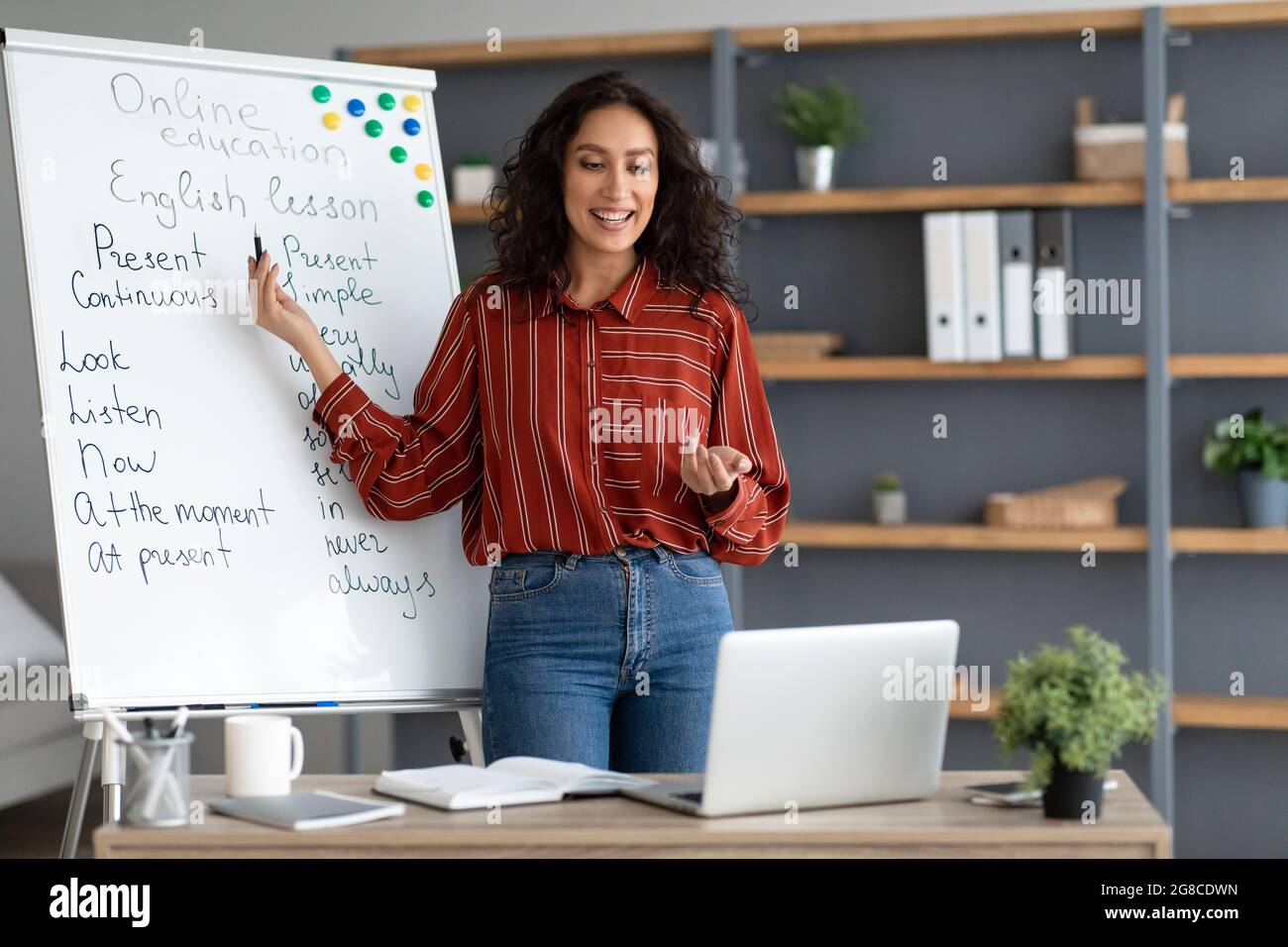 English teacher writing on board, explaining lesson to students Stock ...