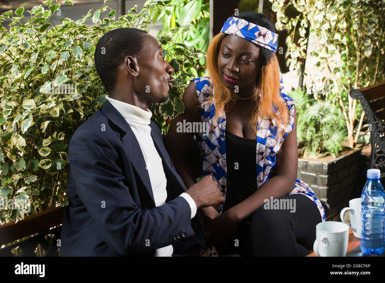 young couple woman and man sitting at outdoor cafe during a sunny day ...