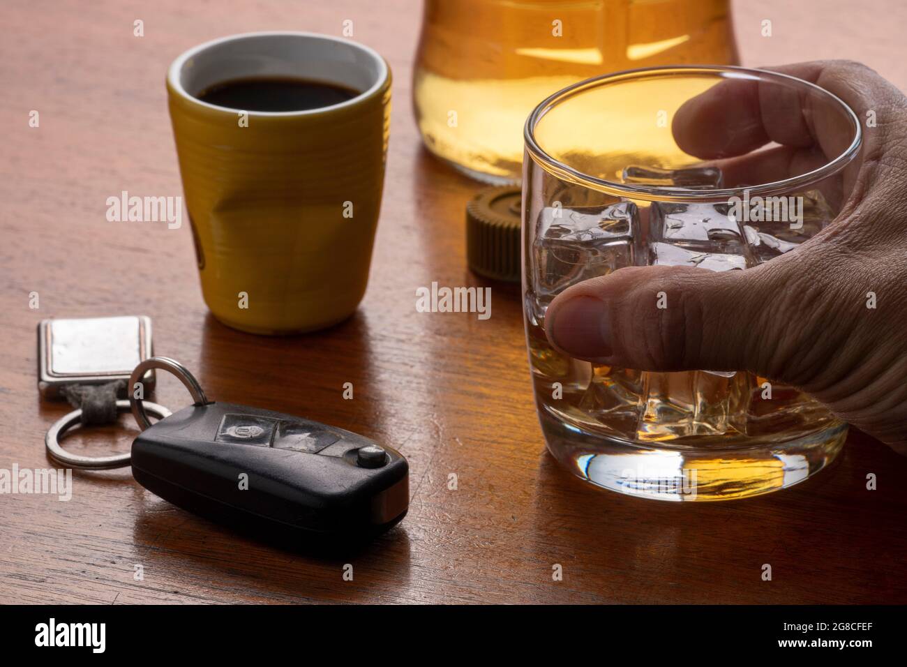 alcohol abuse with glass of whiskey with ice and car key on the table ...