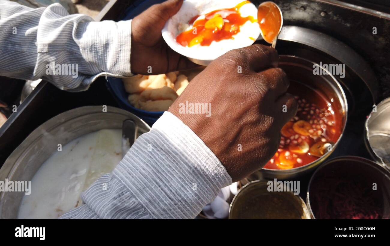 Top view of hands filling famous Delhi street food Dahi Papdi Chat in a ...