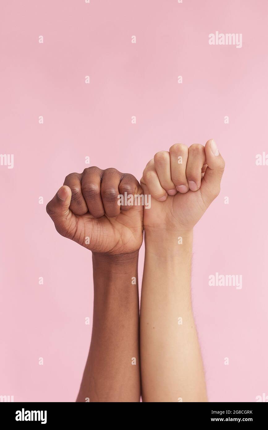 White Caucasian hand and black hand of ethnicity clenched into a fist ...